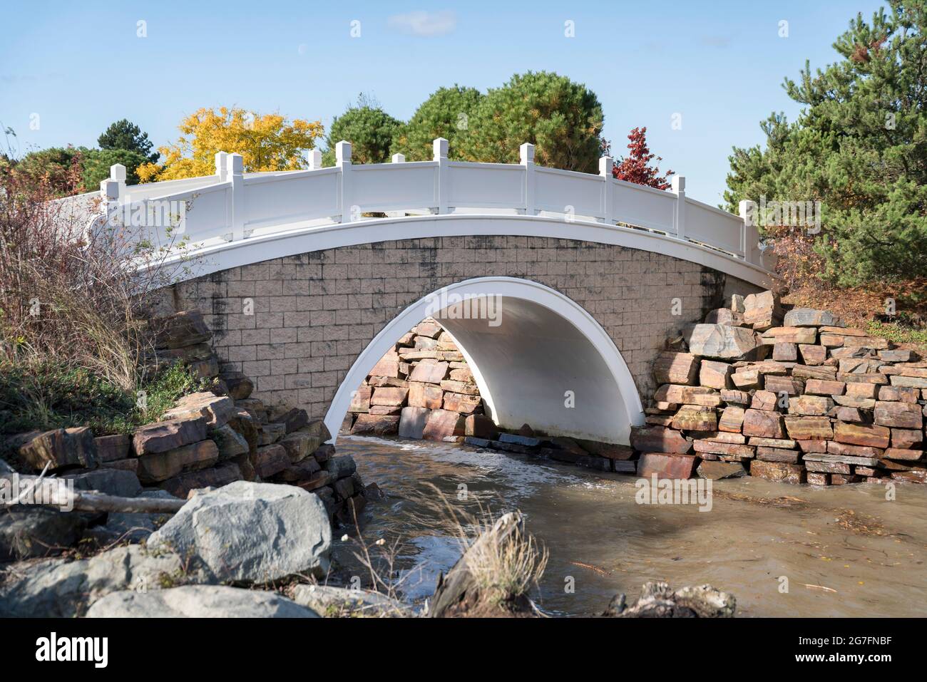 Arched concrete bridge over a river with white railing Stock Photo - Alamy