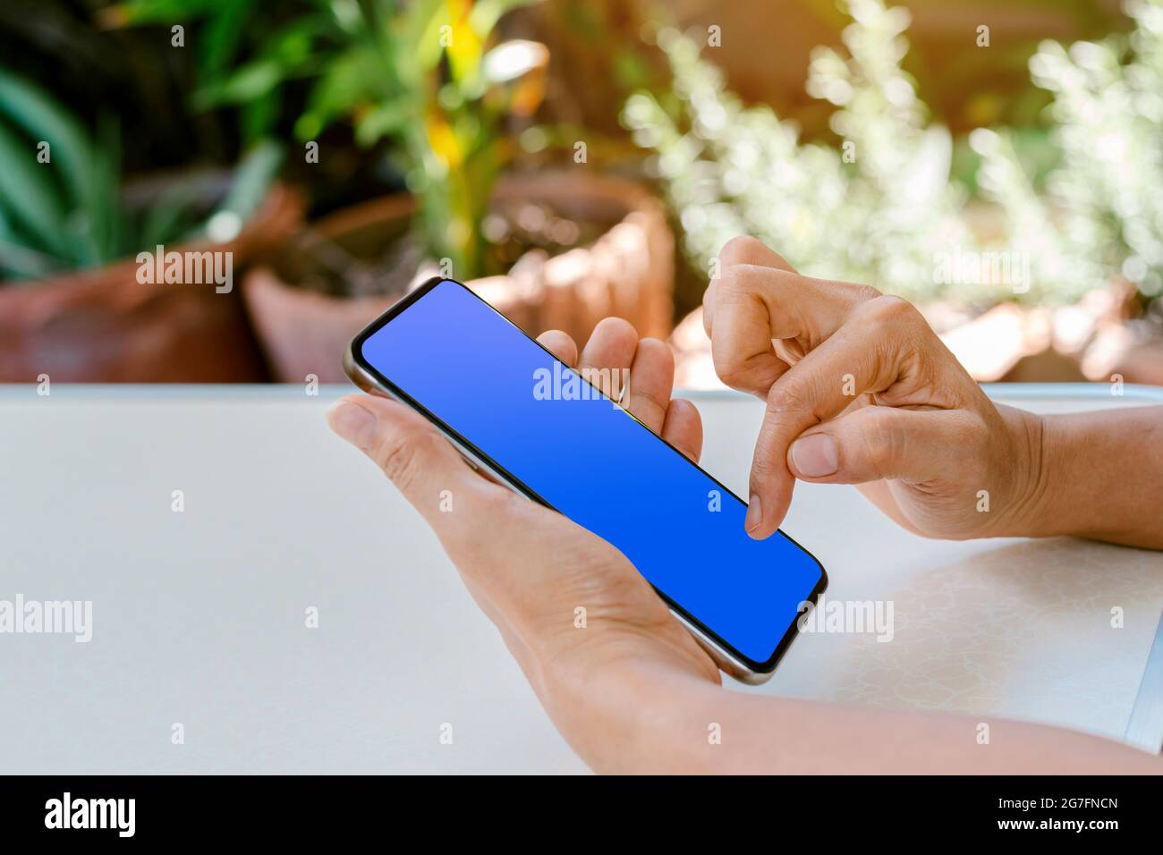 Hand of human touching on blue screen of smart phone, use for using ...