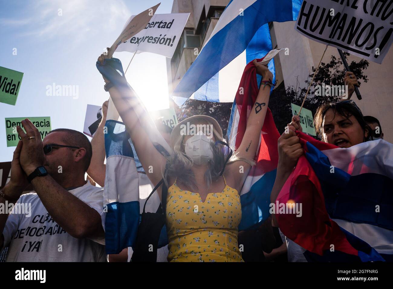 A protester raises her arms while holding a placard, during the ...