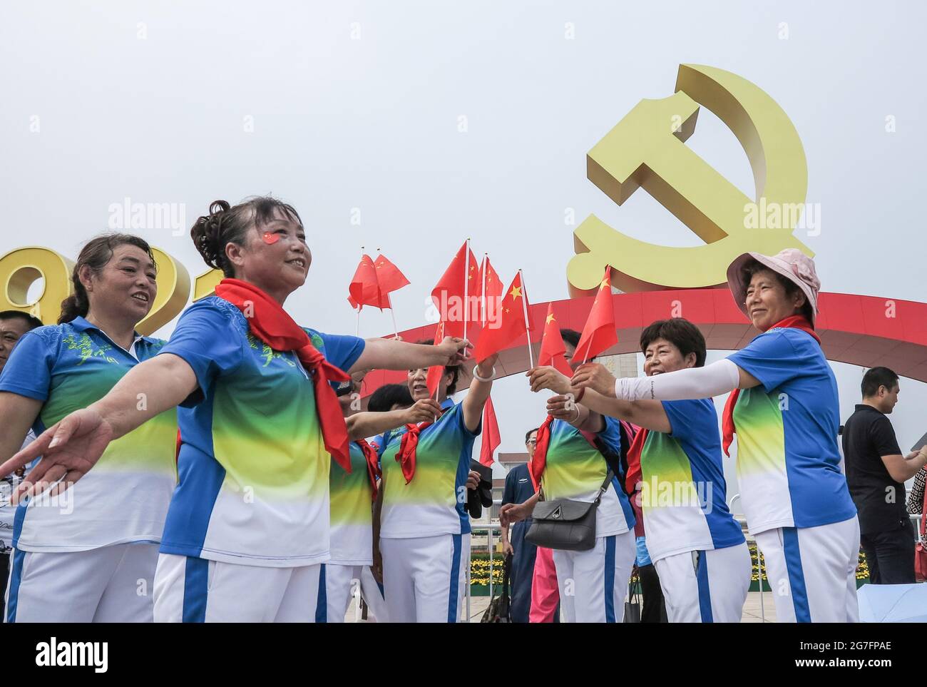 Tourists wearing red scarves, uniform clothes hold national flags while ...