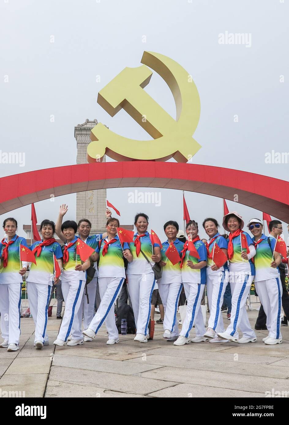 Tourists wearing red scarves, uniform clothes hold national flags while ...