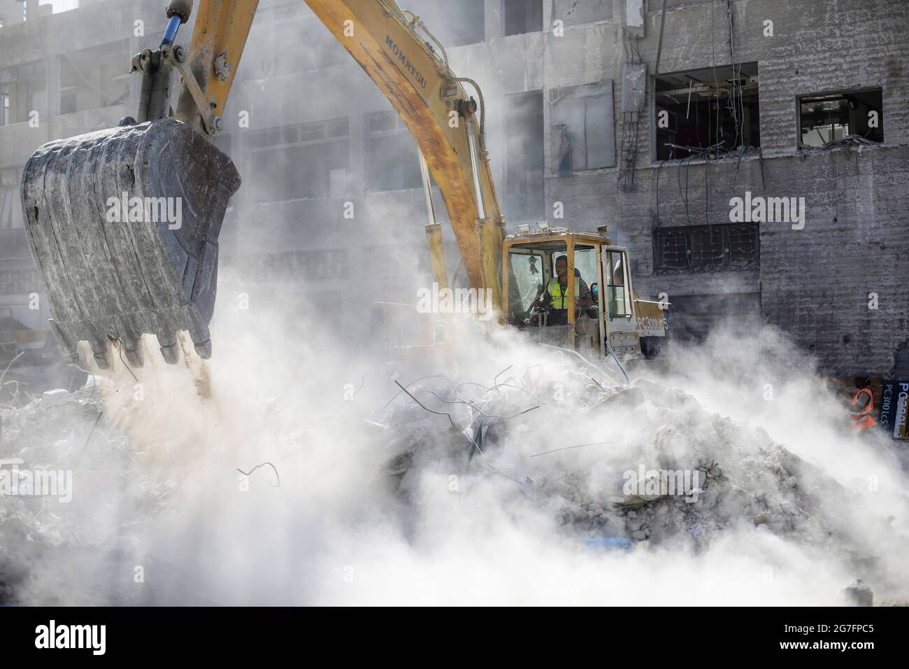 Egyptian workers with machines remove the rubble of the destroyed ...