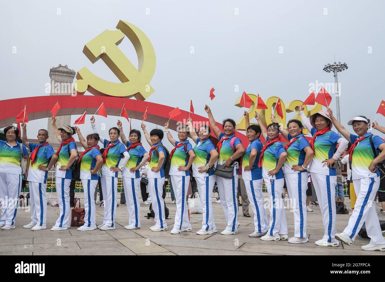 Tourists wearing red scarves, uniform clothes hold national flags while ...
