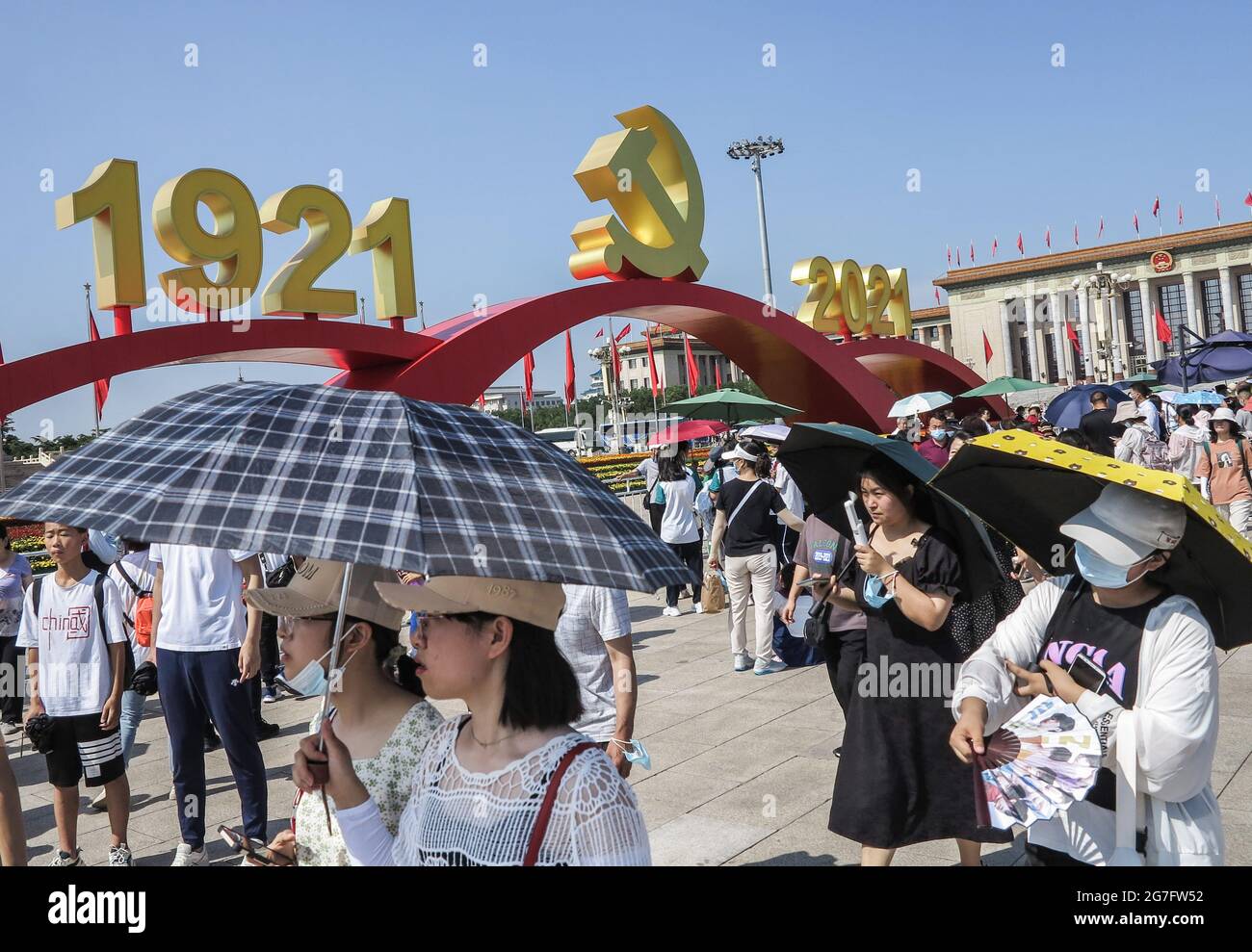 Beijing, China. 09th July, 2021. Tourists walk under a Communist Party ...
