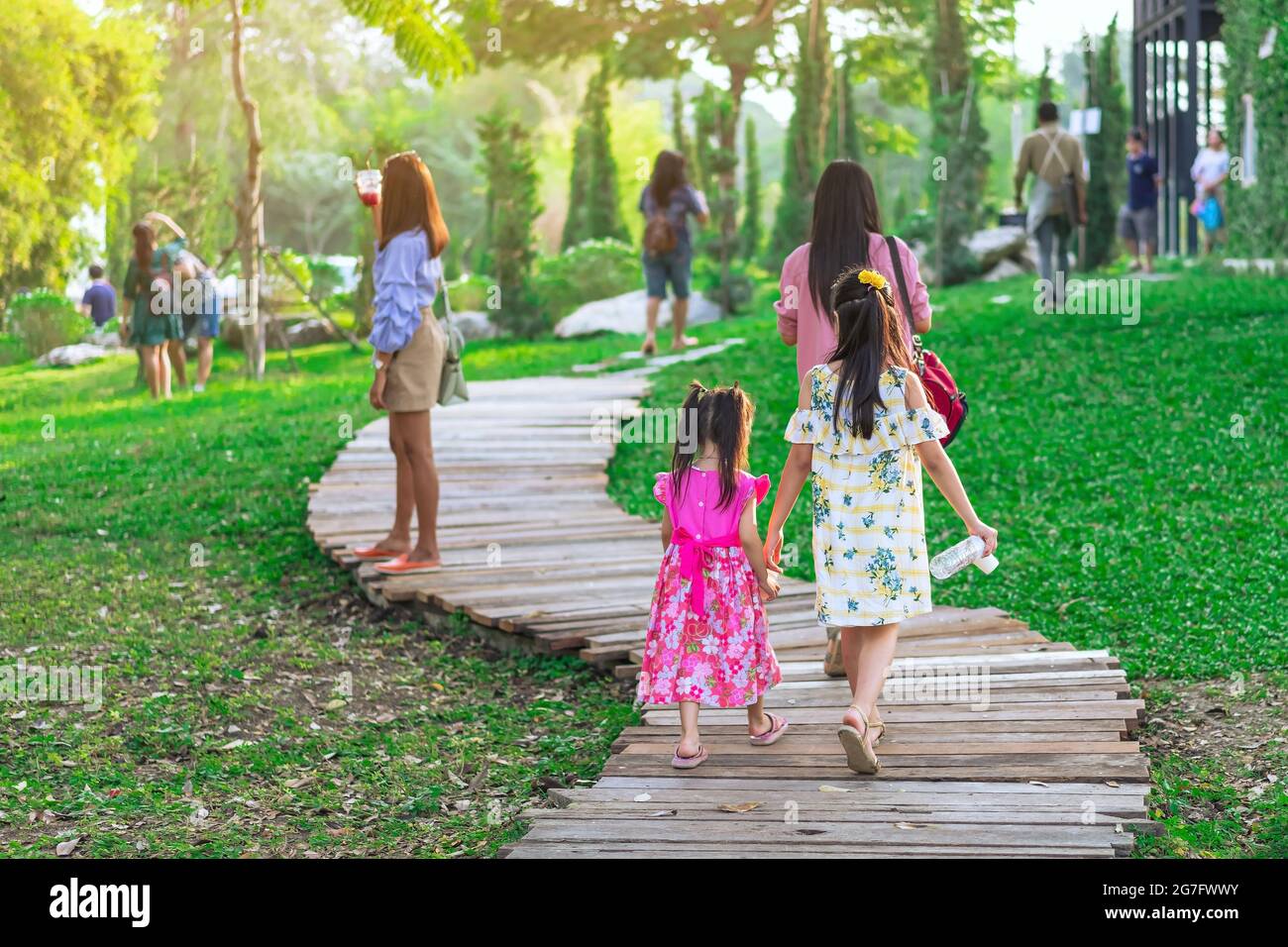 Back view of Asian little girls walking side by side on pathway through ...