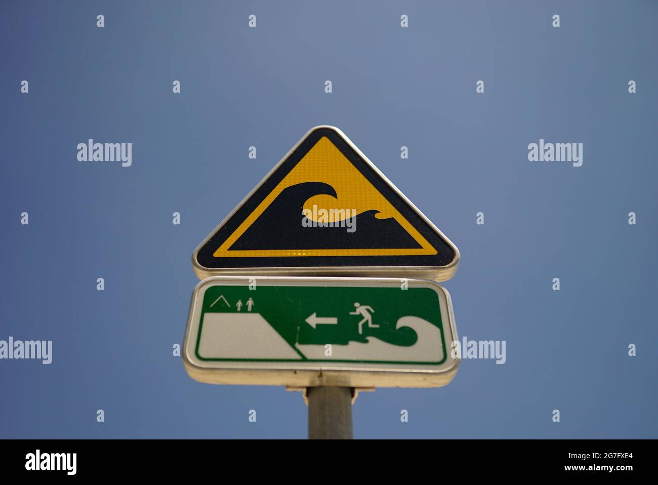 Emergency exit and wave warning road signs on blue backgound Stock ...