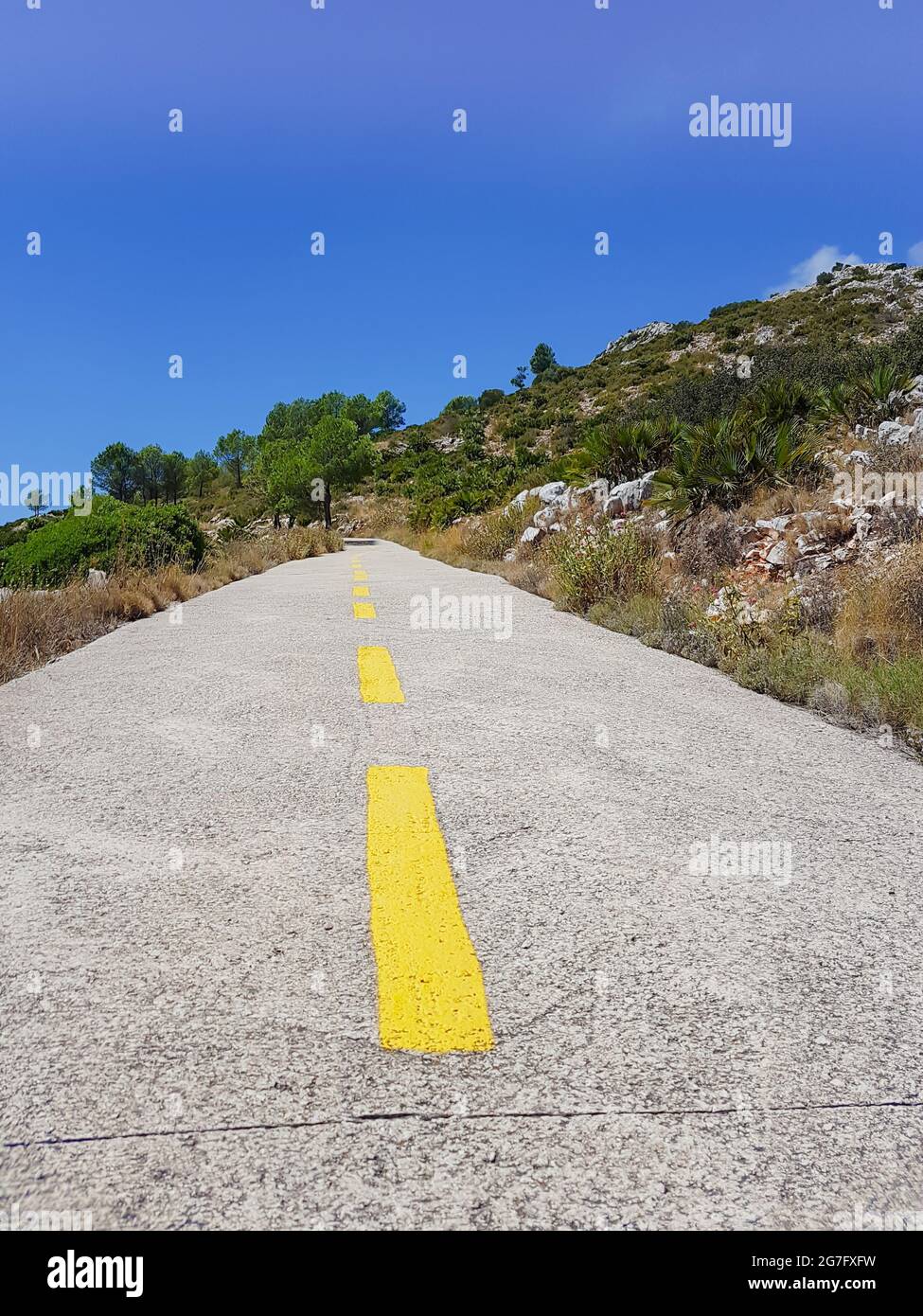 Road with yellow lines climbing uphill through Col de rates, famous ...