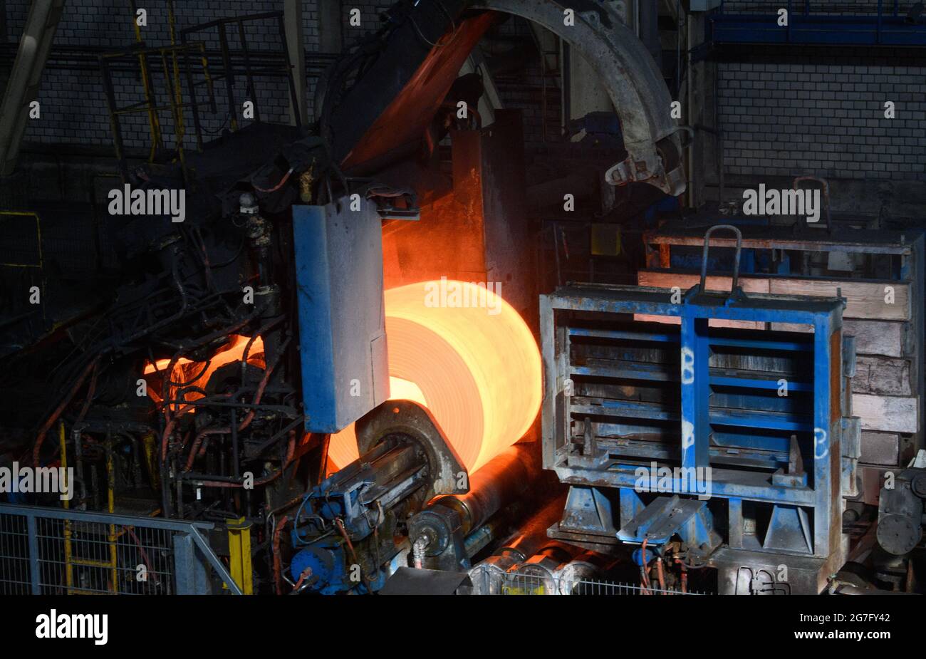 13 July 2021, Brandenburg, Eisenhüttenstadt: A red-hot slab is wound ...