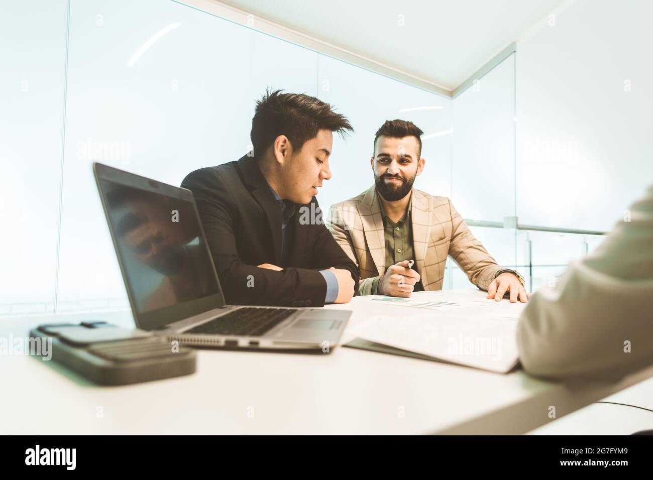 A team of young businessmen working and communicating together in an ...