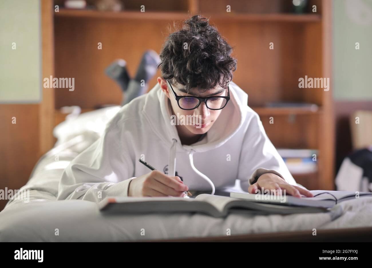 Teen boy studying on bed hi-res stock photography and images - Alamy