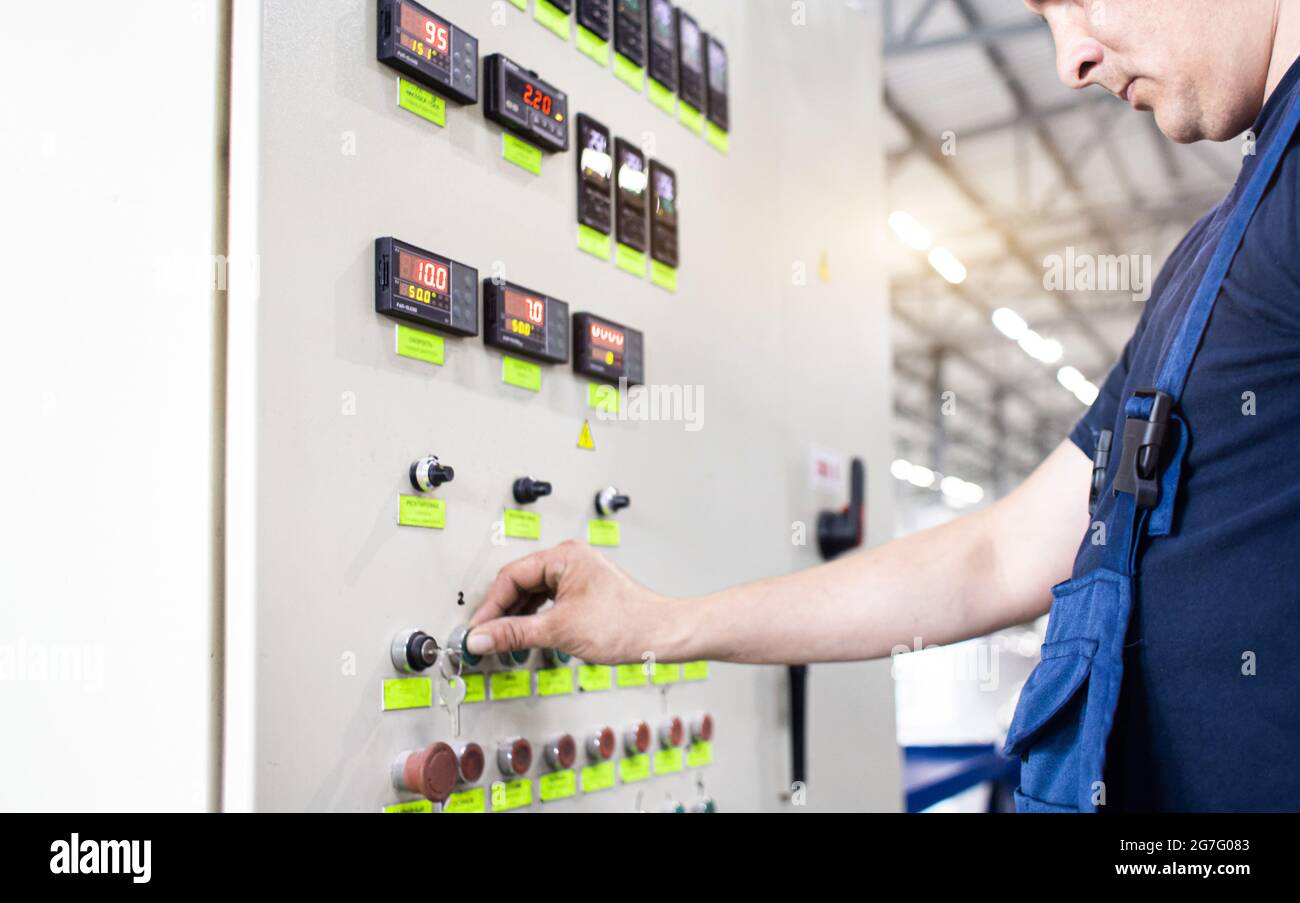A worker presses a button and starts an automatic manufacturing process ...