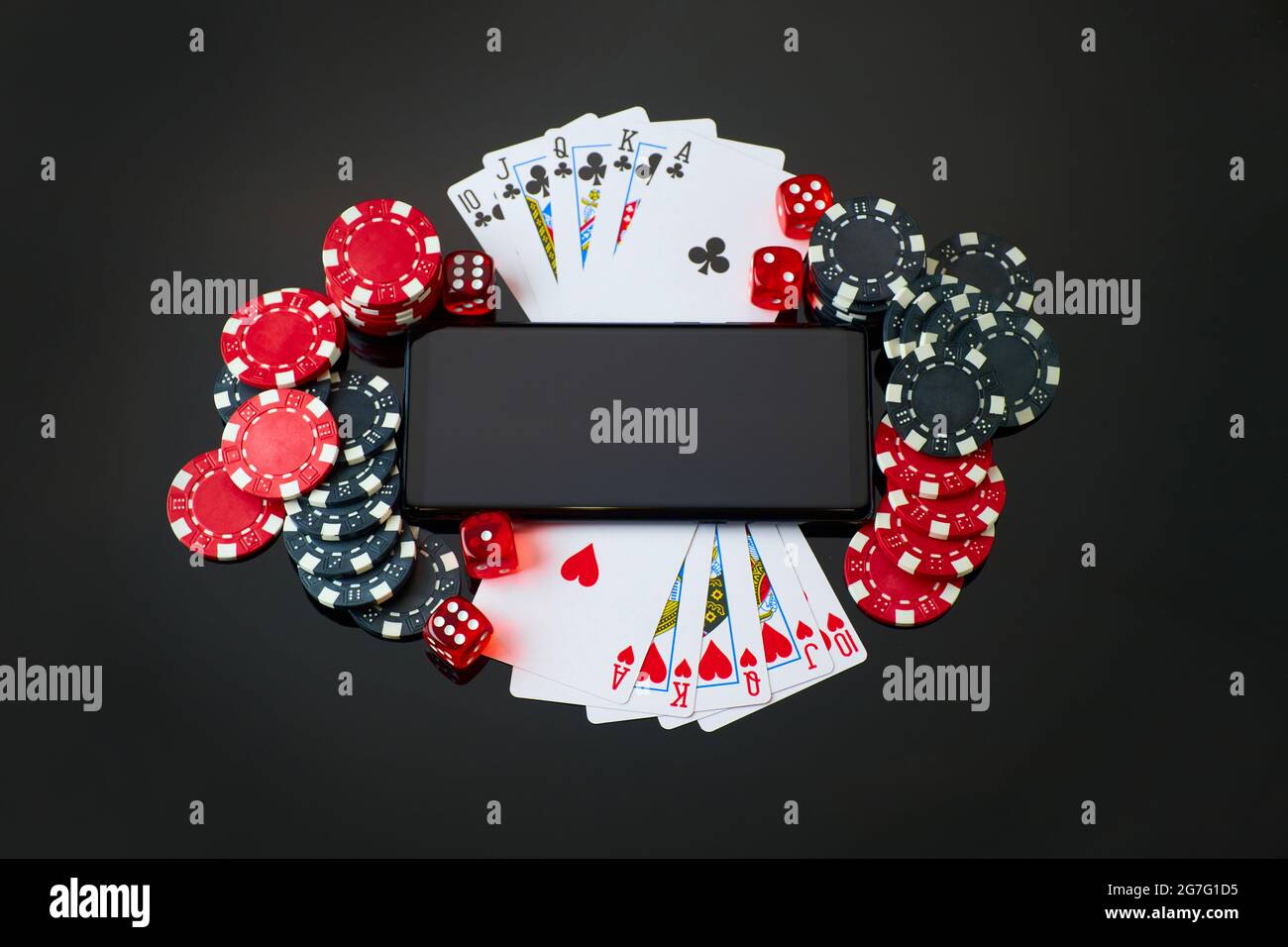 Casino chips, playing cards, dices and mobile phone on dark reflective ...