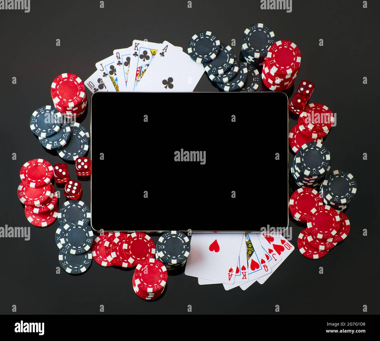 Casino chips, playing cards, dices and tablet pc pad on dark reflective ...
