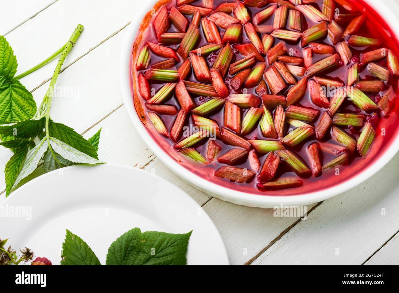 Jellied pie or cake with rhubarb stalks and raspberries. Summer sweet ...