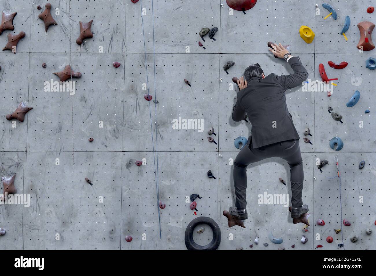 Asian businessman climb the rock climbing wall at outdoor Stock Photo ...