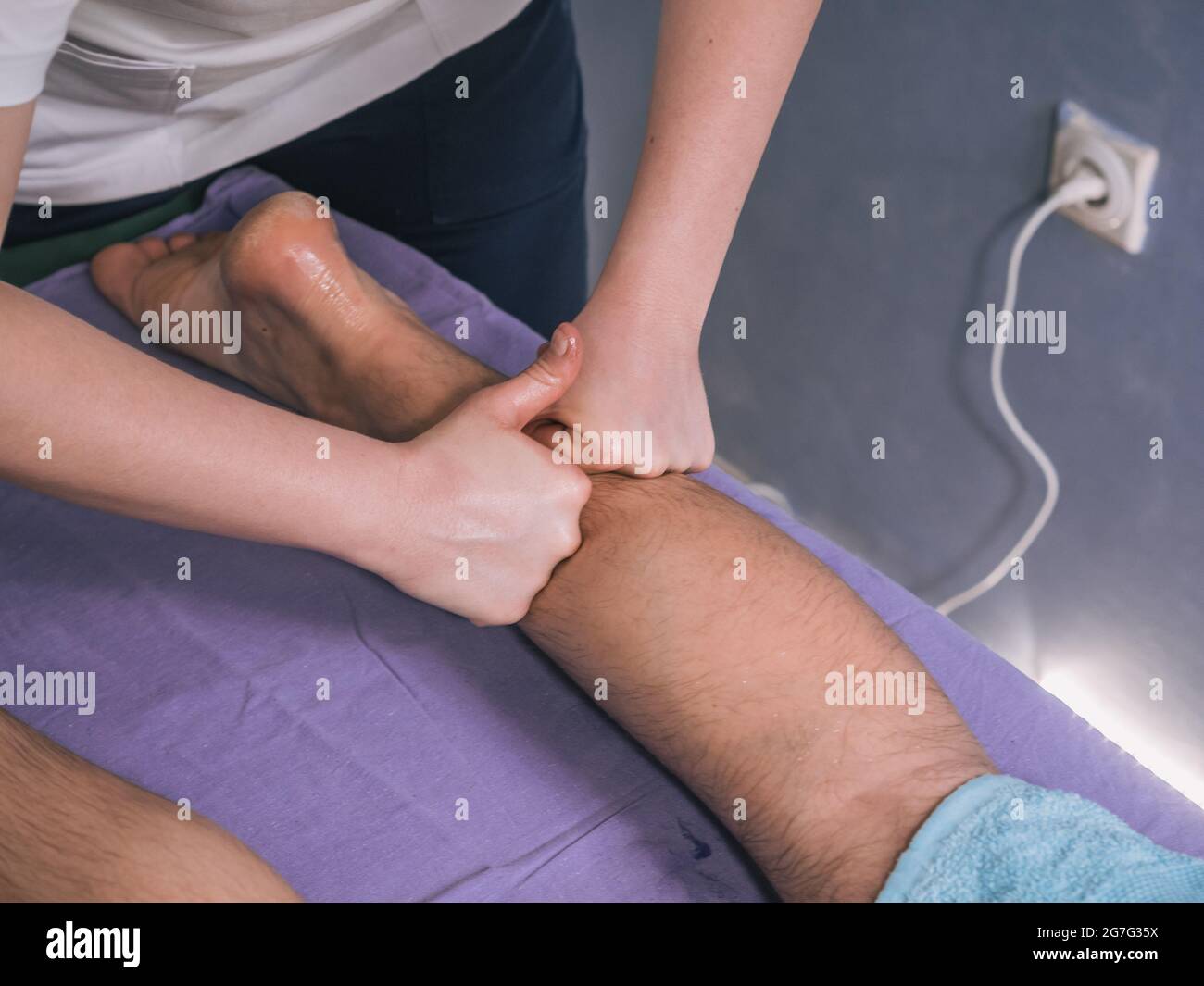 two people, physiotherapist massaging man's leg muscles - calves Stock ...