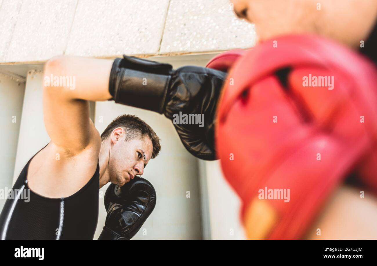 Two men exercising and fighting in outside. Boxer in gloves is training ...