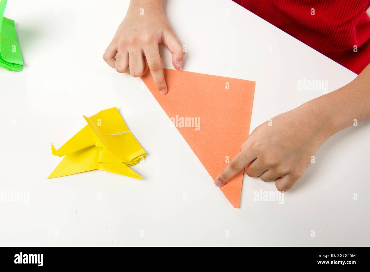 Little girl folding a paper isolated over white background Stock Photo ...