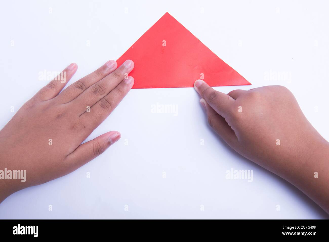 Human hand folding a colored paper isolated over white background Stock ...