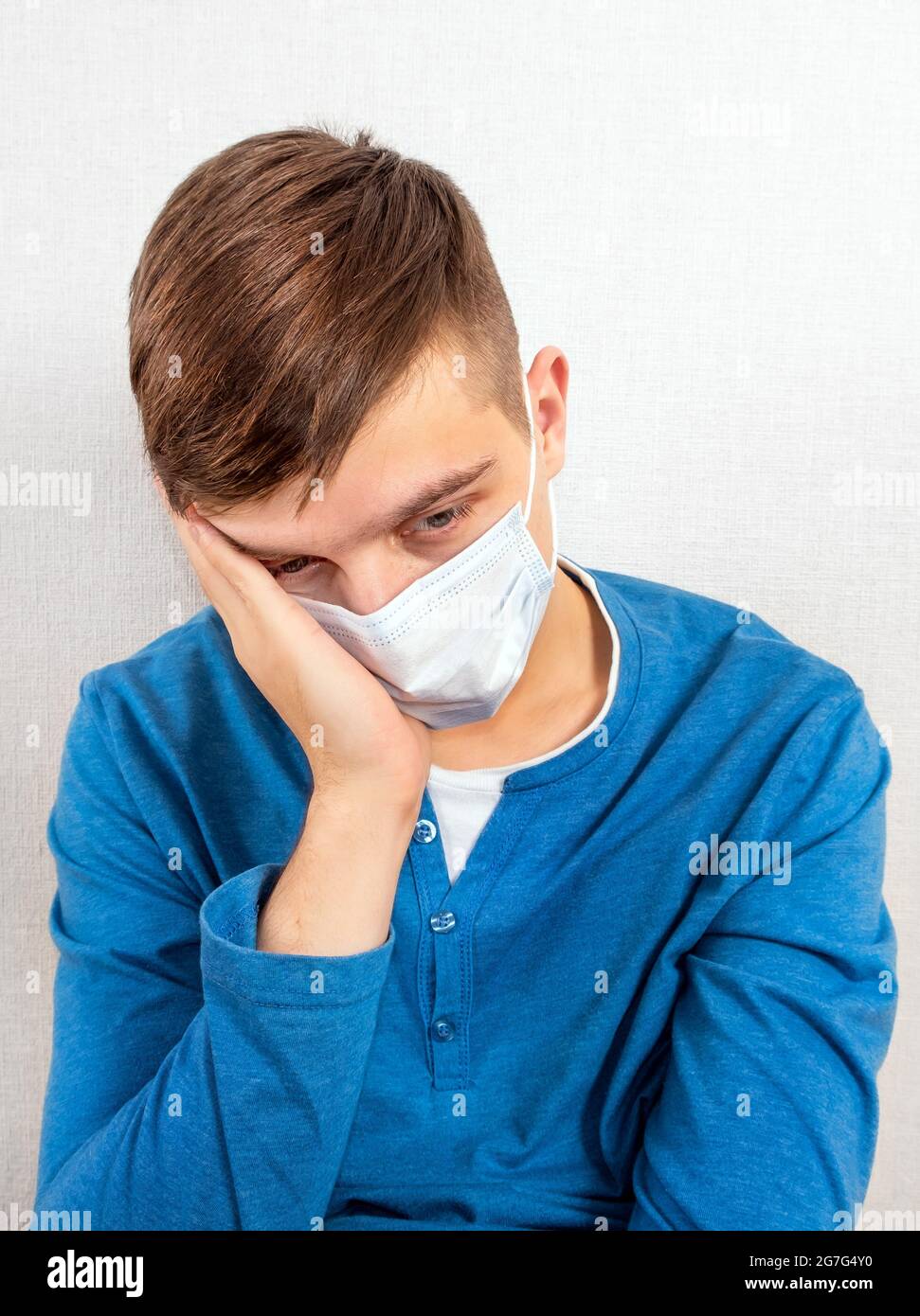 Sad and Tired Young Man in a Flu Mask by the Wall in the Room Stock ...