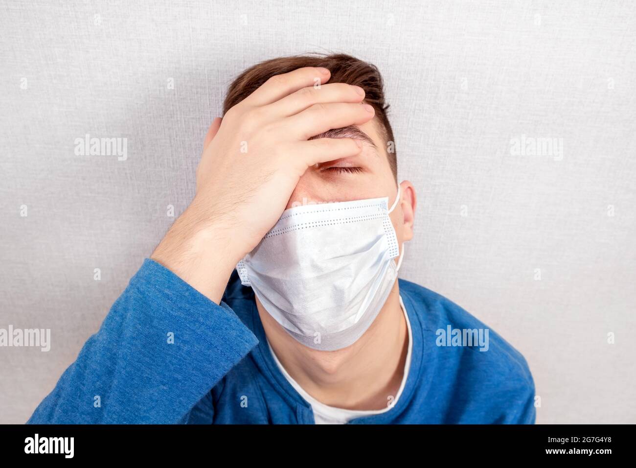 Painful Young Man in a Flu Mask by the Wall in the Room Stock Photo - Alamy