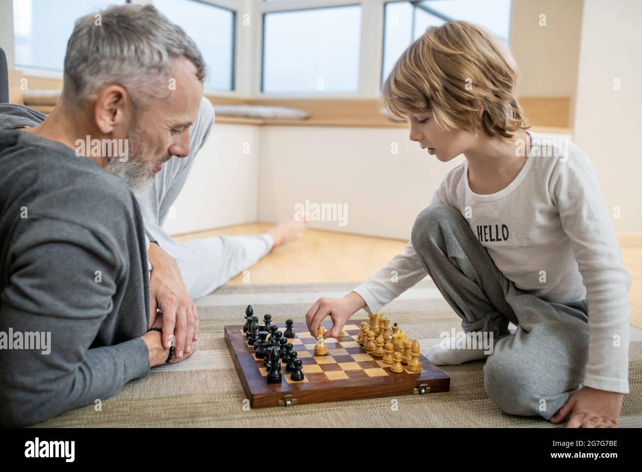 Father and son playing chess and looking involved Stock Photo - Alamy