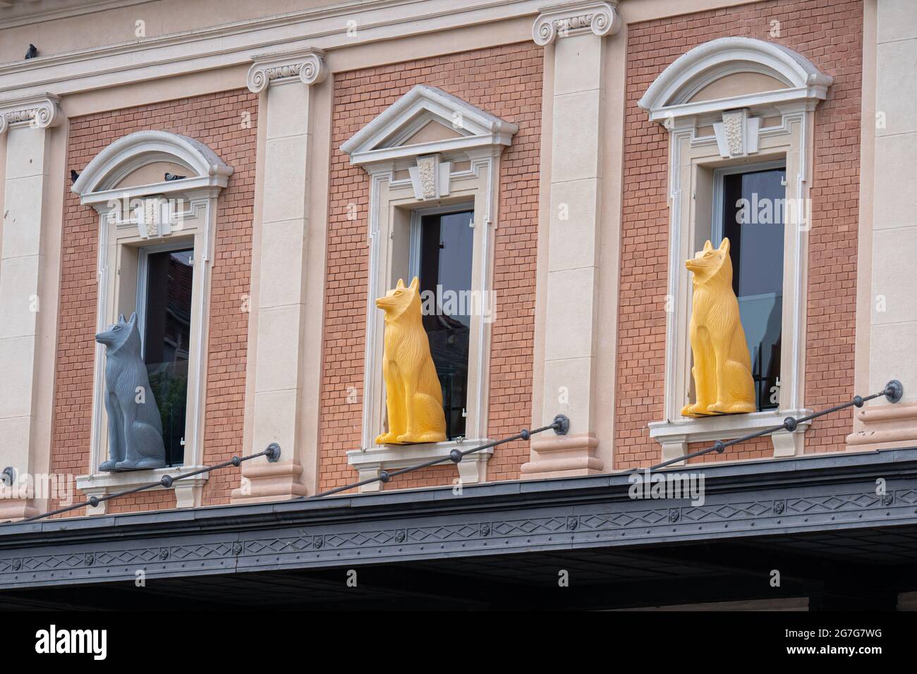 Sculptures of Yellow and Gray Wolves Leaning Against the Outside of ...