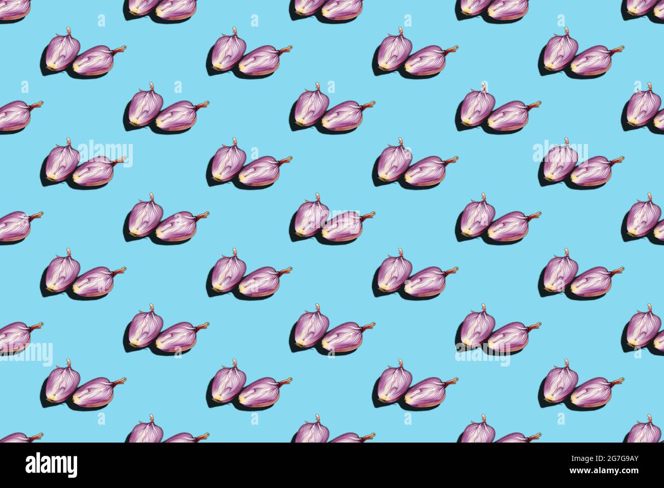 Repeated Two halves of ripe raw unpeeled onion on blue white background ...