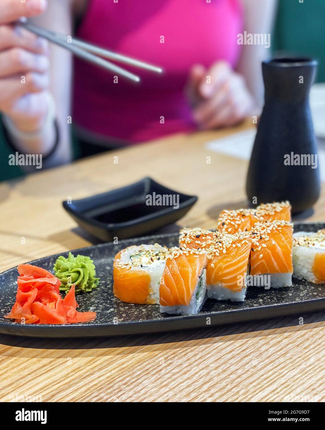 Eating roll sushi in japanese restaurant, hand with chopsticks Stock ...