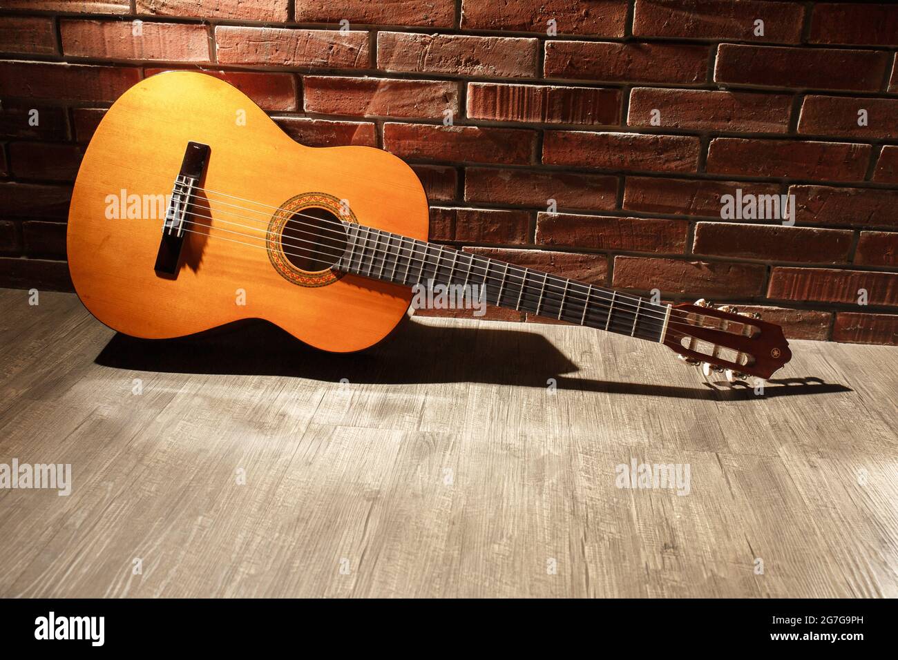 Horisontal classical guitar on brick background Stock Photo - Alamy