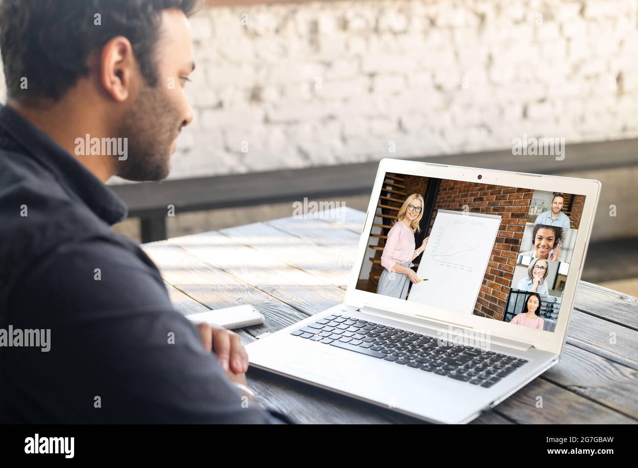 Indian male student is studying online, using laptop computer for ...