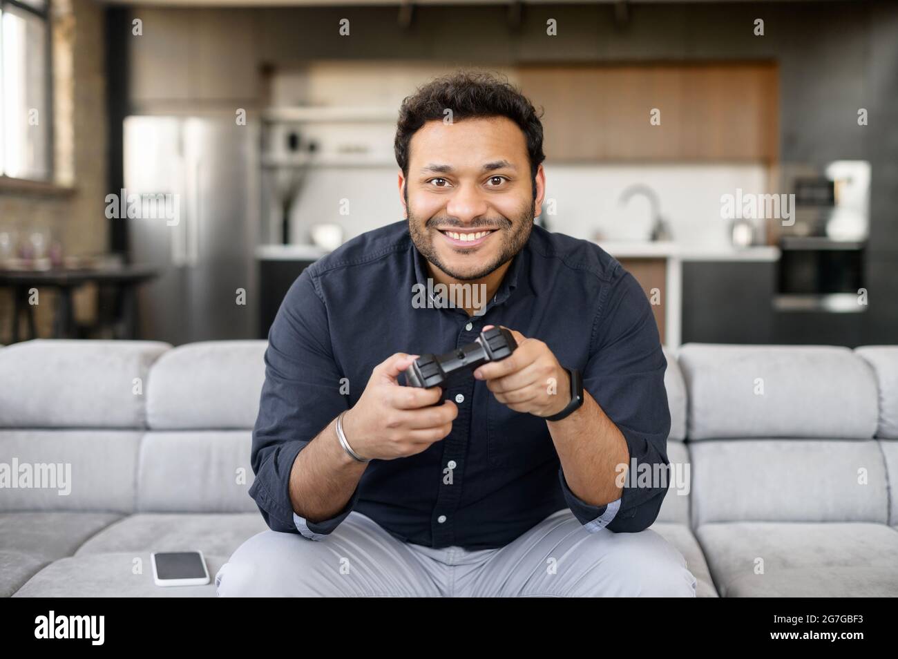 Handsome excited young indian man spends leisure time playing video ...