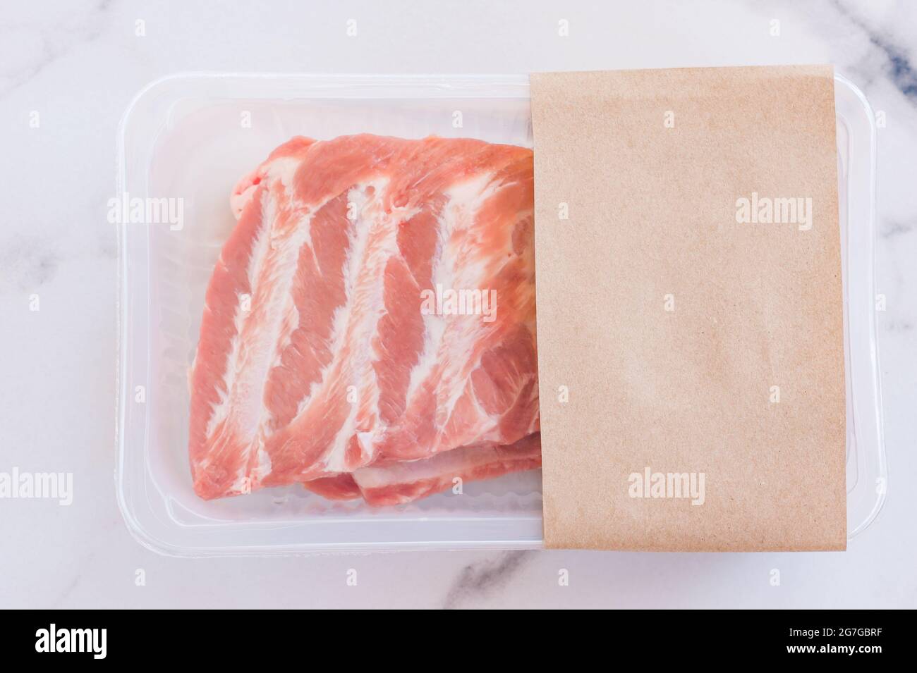 Raw pork ribs in vacuum packaging on marble background, logo mockup for ...