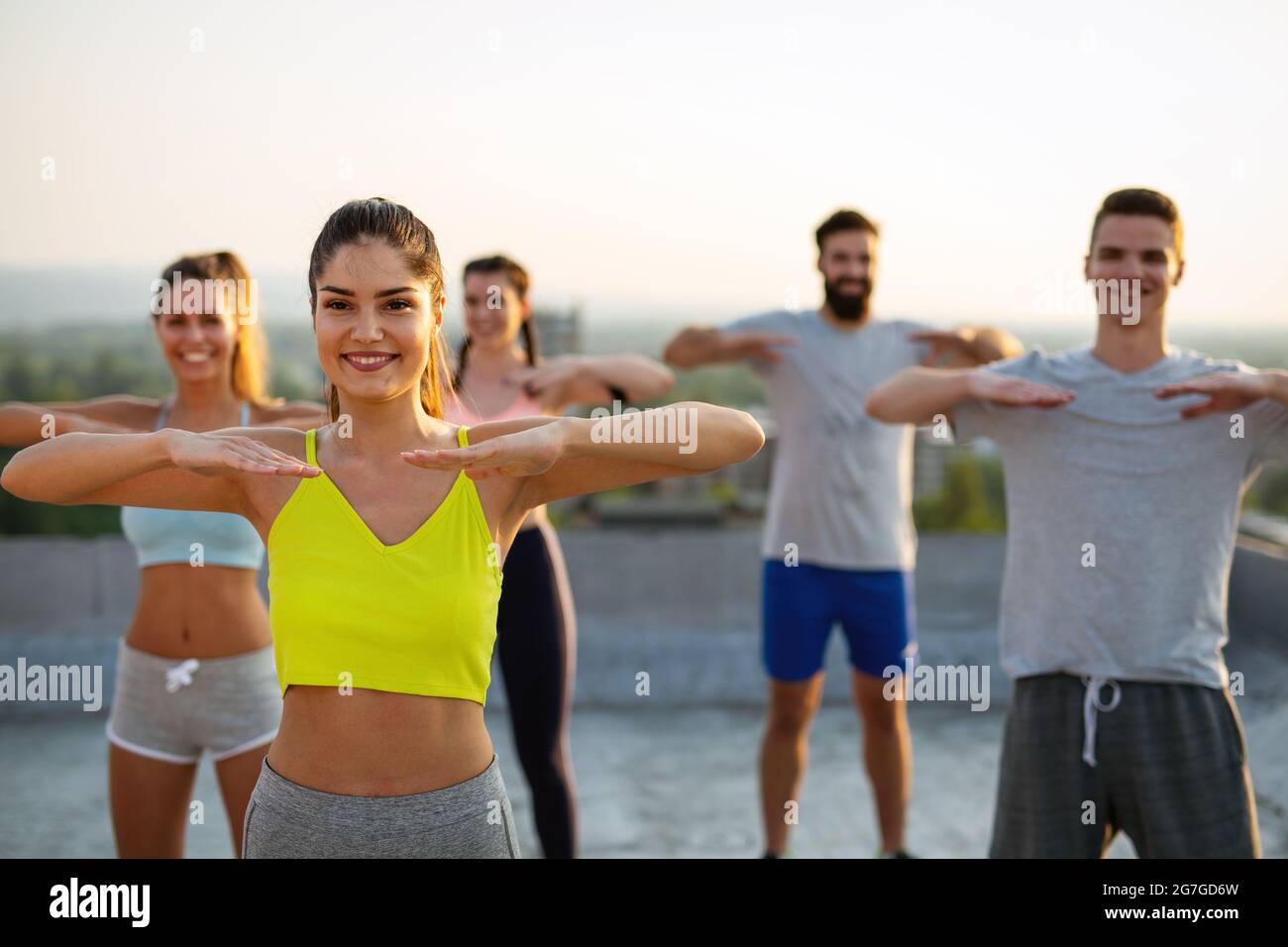 Group of happy fitness people training together outdoors, living active ...