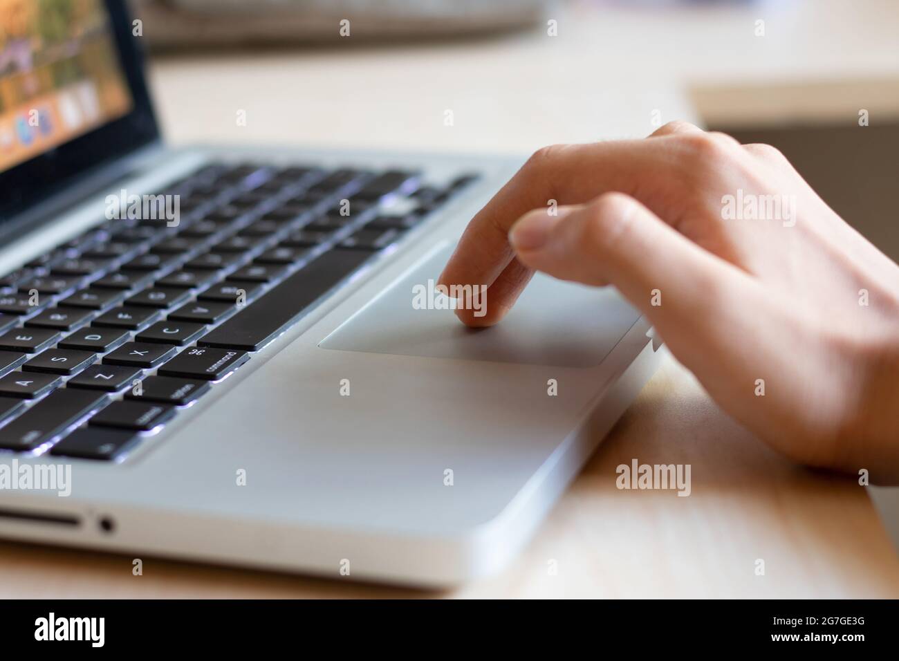 A young man's hand using a trackpad on a laptop Stock Photo - Alamy