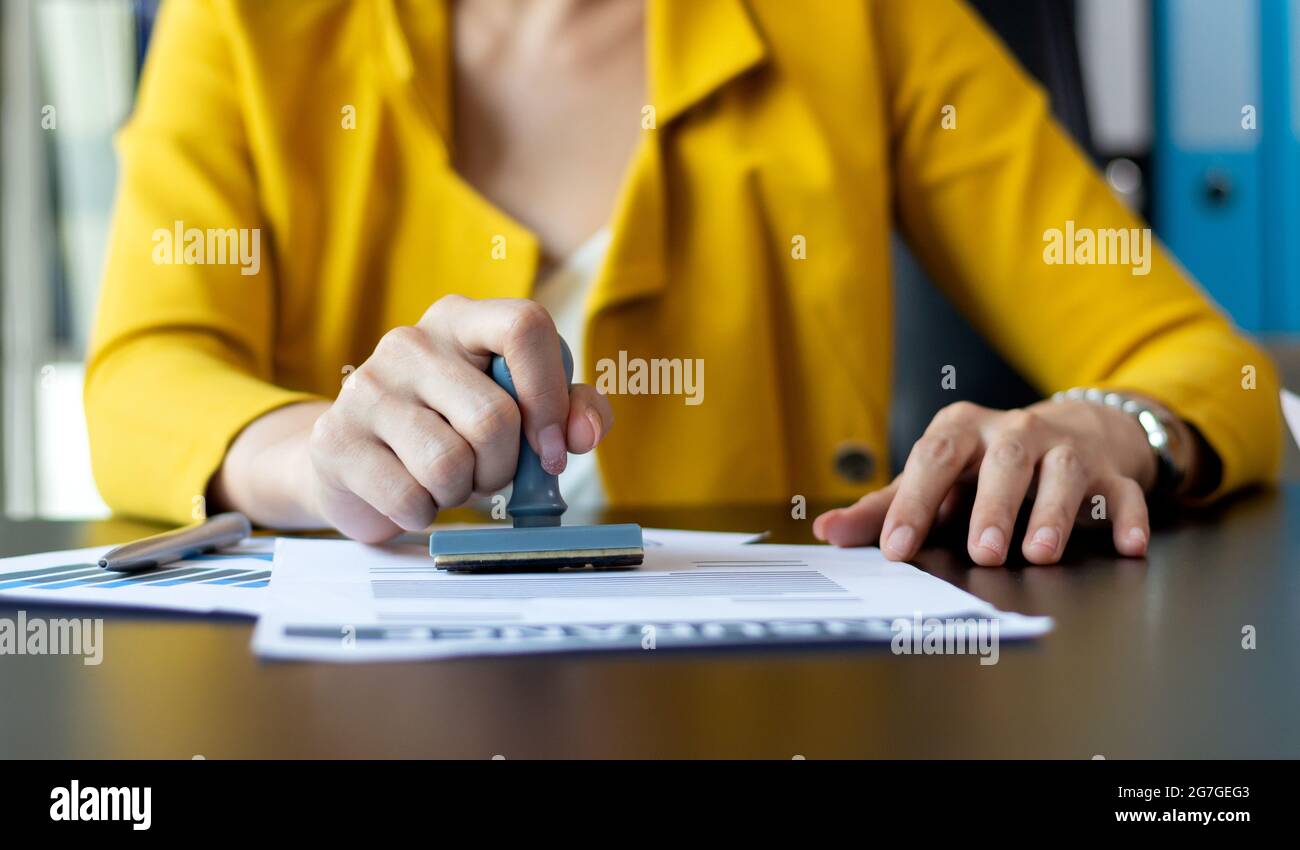 Close-up hand woman Stamping With Approved Stamp On Document At Desk ...