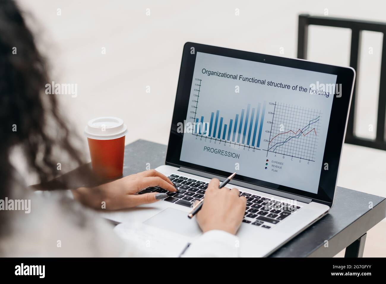 close-up. young woman checking financial data sitting at a table in a ...