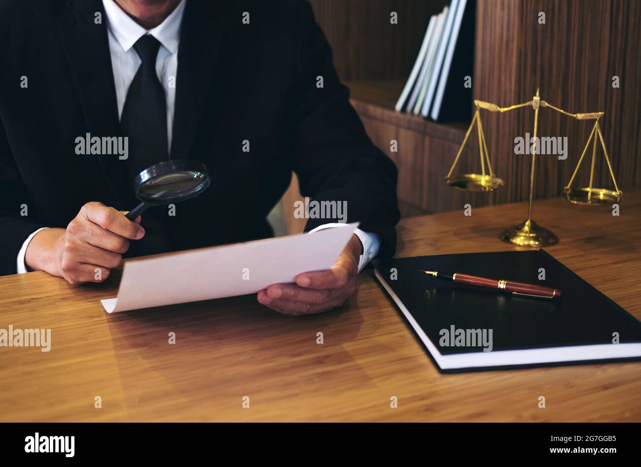 Male lawyer reading legal contract agreement and examining documents ...