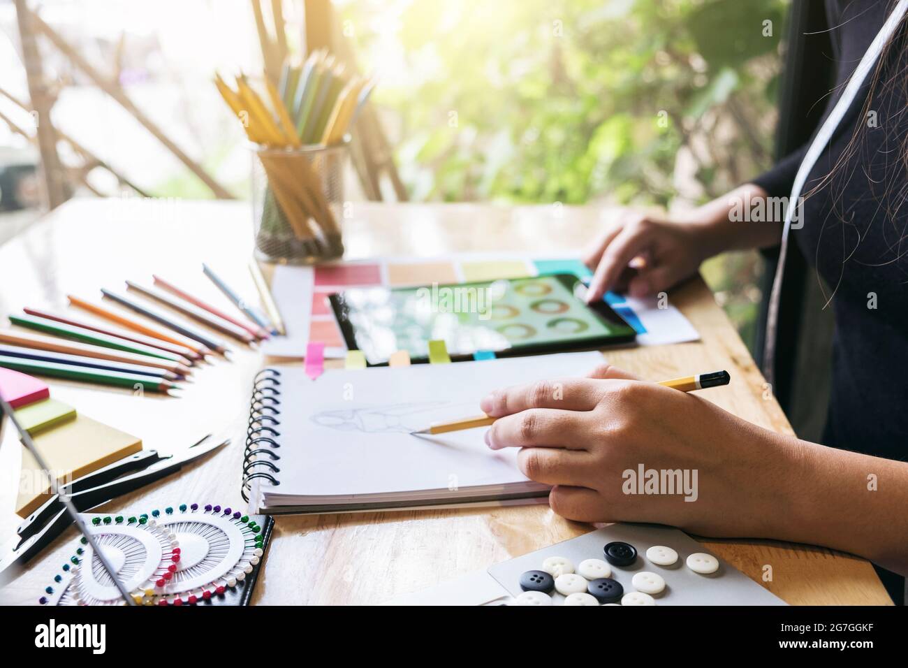 Young woman dressmaker or designer working as fashion designers and ...