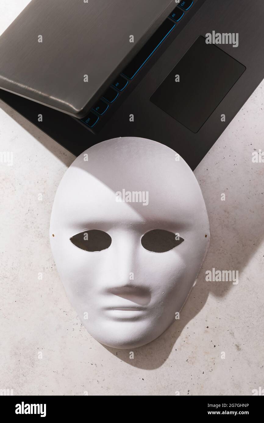 Top view of white cardboard mask and laptop, internet anonymity concept ...