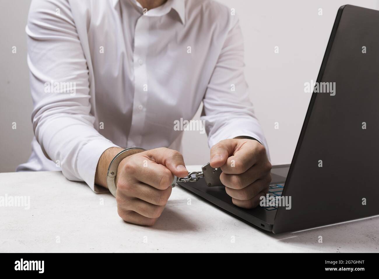 Hacker in handcuffs near laptop, concept of computer crimes Stock Photo ...