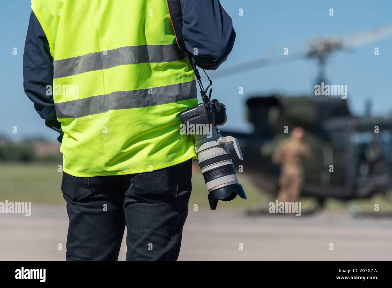 A military photographer, a reporter, in a signal yellow vest, ready to ...