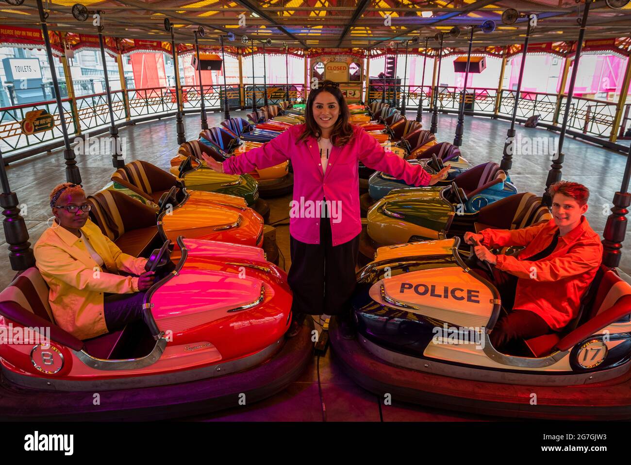London, UK. 14 July 2021. Models posing in dodgem cars in DODGE, a full ...