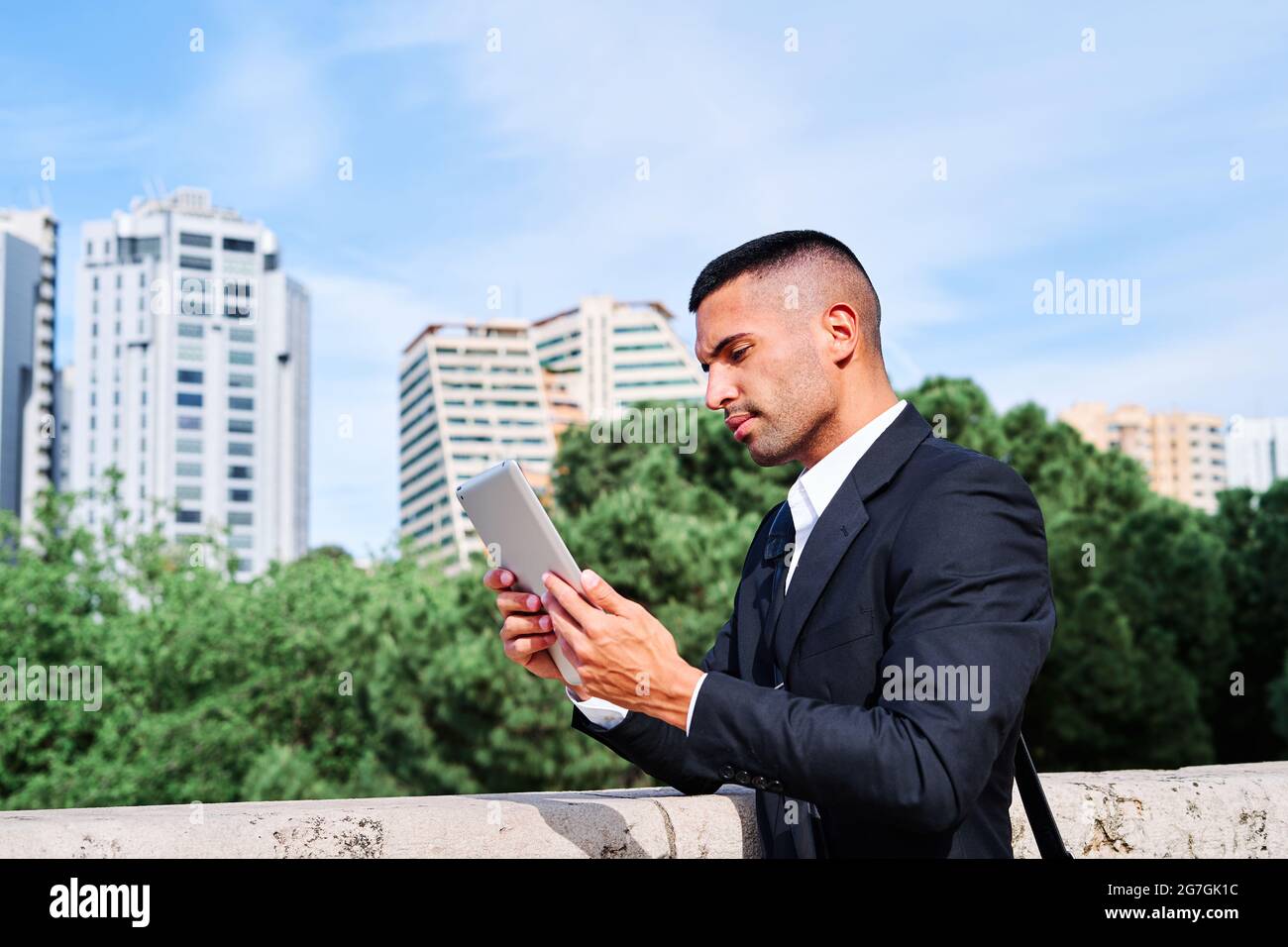 Side view of focused young Hispanic male executive manager in classy ...