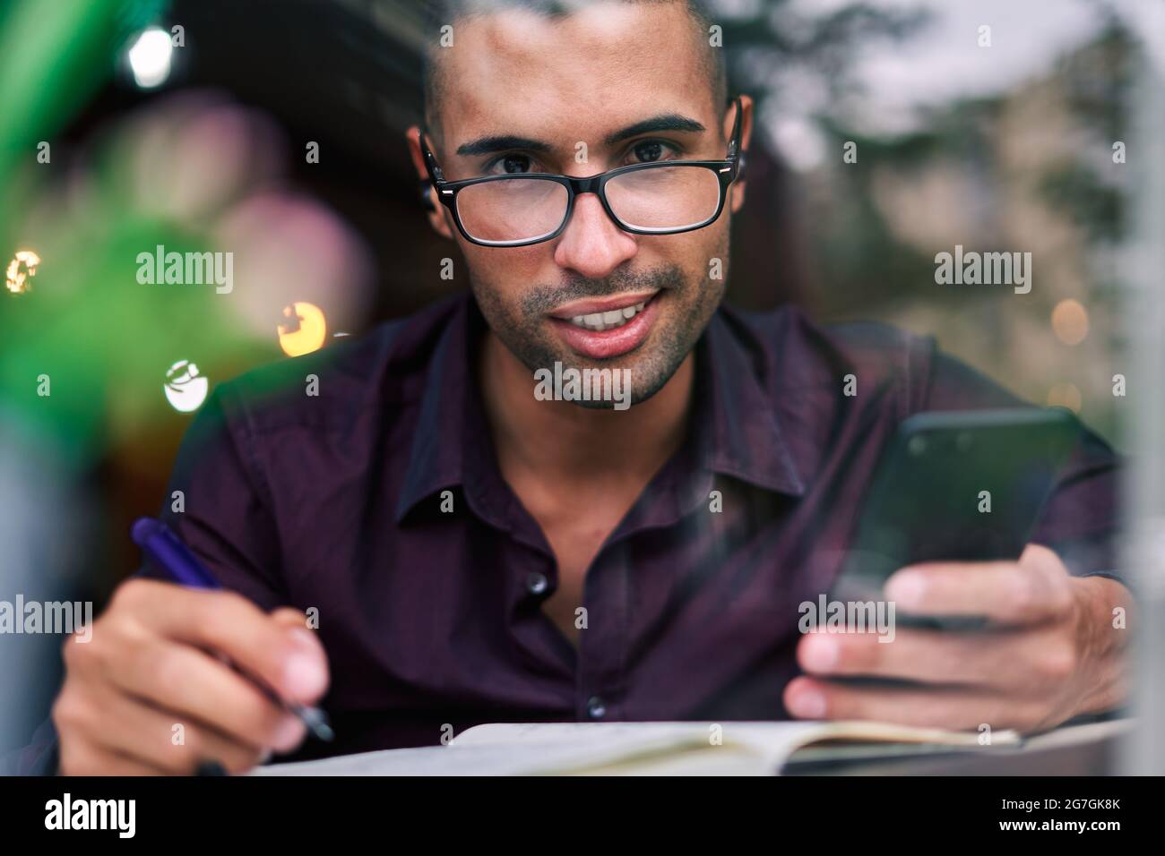 Focused Hispanic male entrepreneur sitting on passenger seat of car and ...