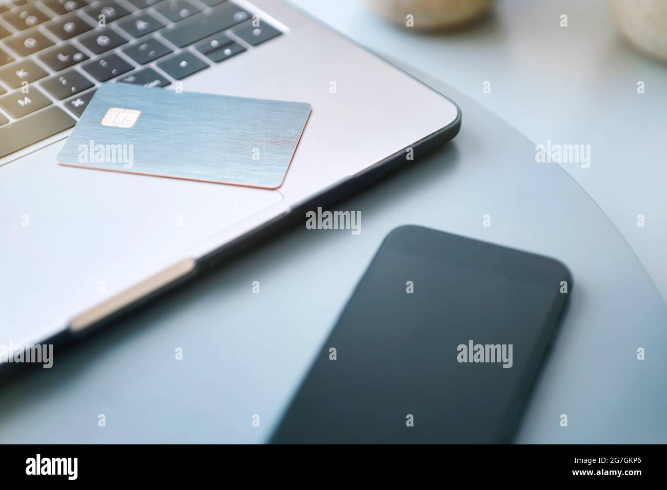 Laptop, electronic chip card and smartphone on blue round table. Paying ...