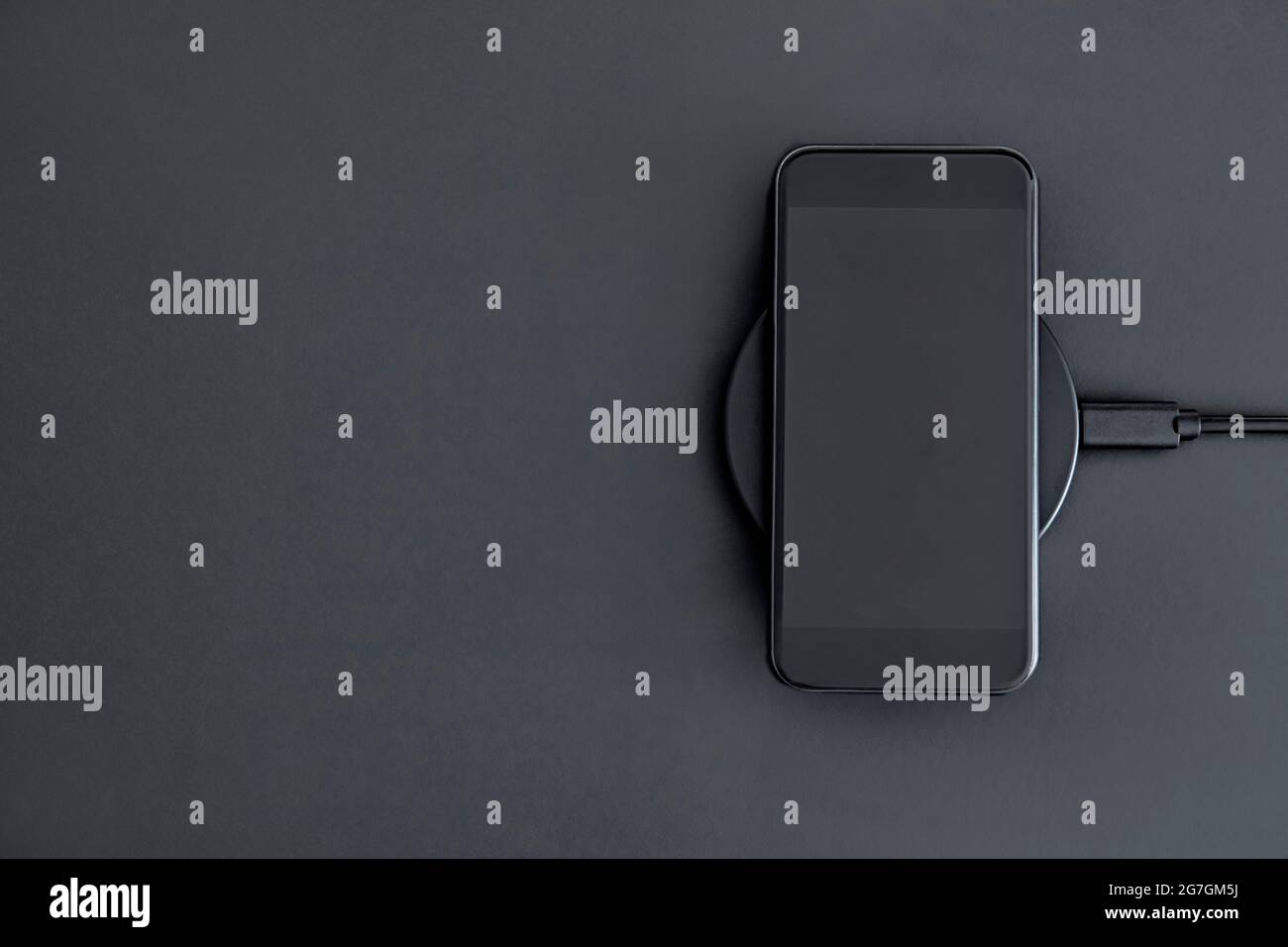 Induction wireless charging of mobile phone. High angle view of ...