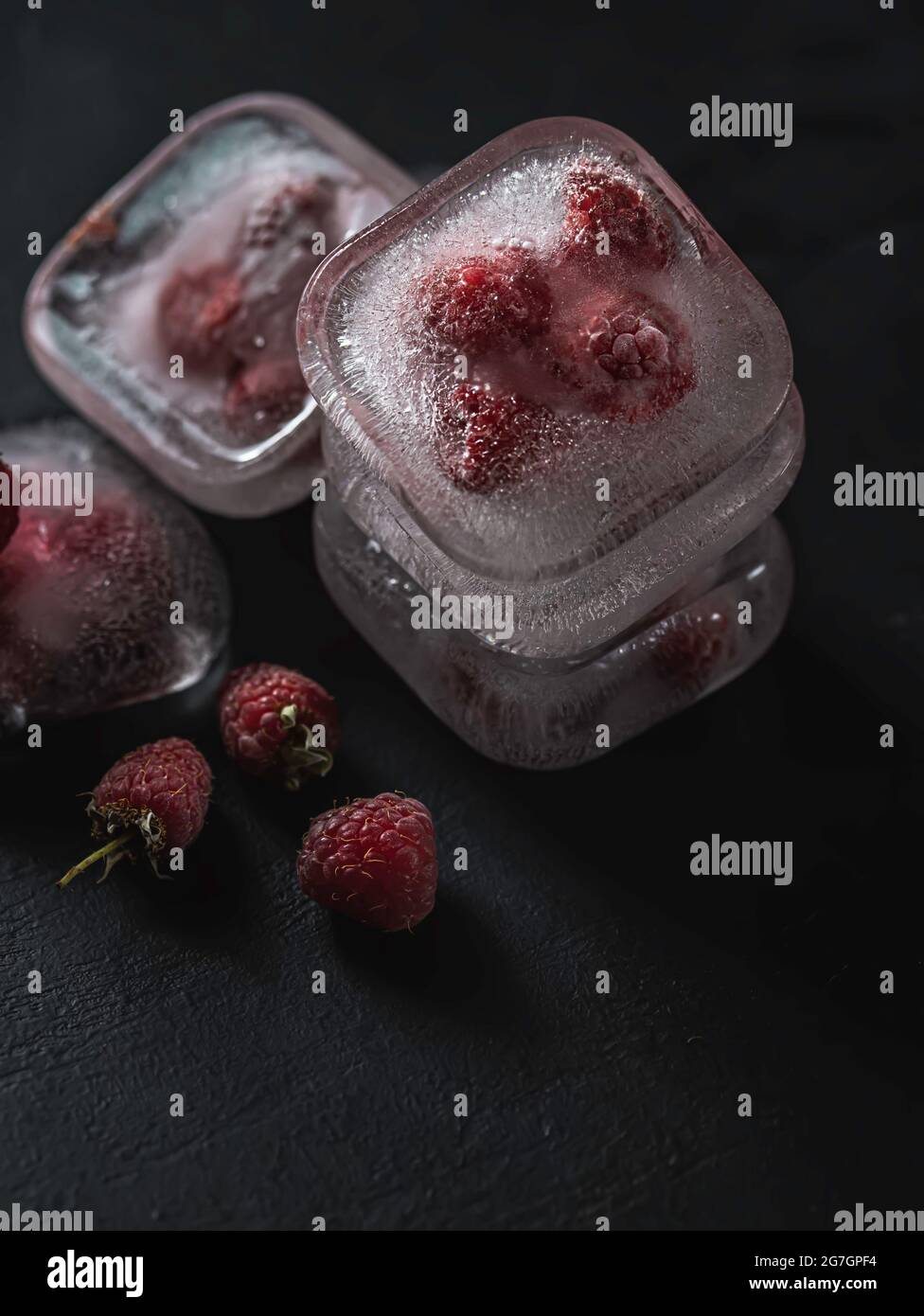 Raspberry frozen in the ice cube on black background. Fresh healthy ...