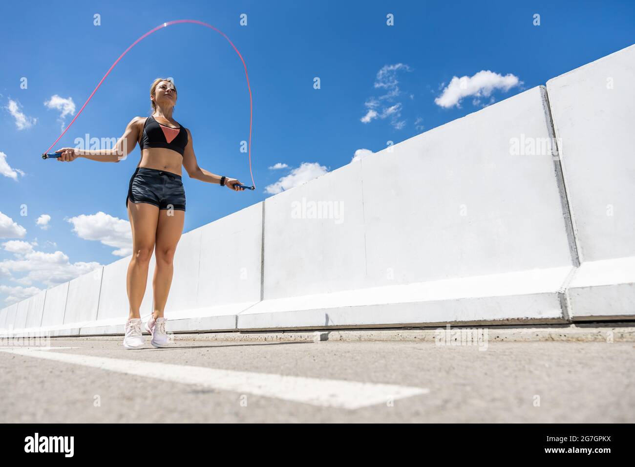 Young Woman training with the outdoor skipping rope , side view Stock ...