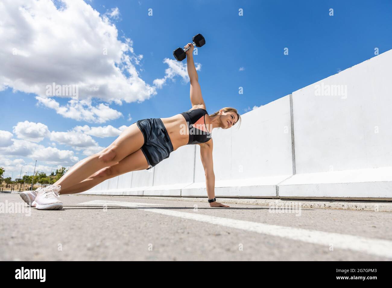 Young Woman training with her dumbbell outdoors, dumbbell bending and ...